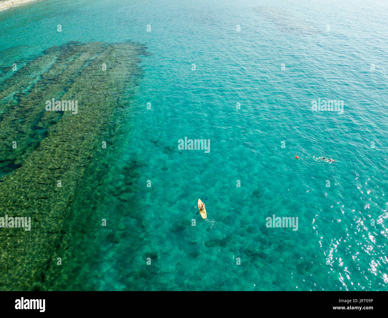 Aerial view of a canoe in the water floating on a transparent sea ...