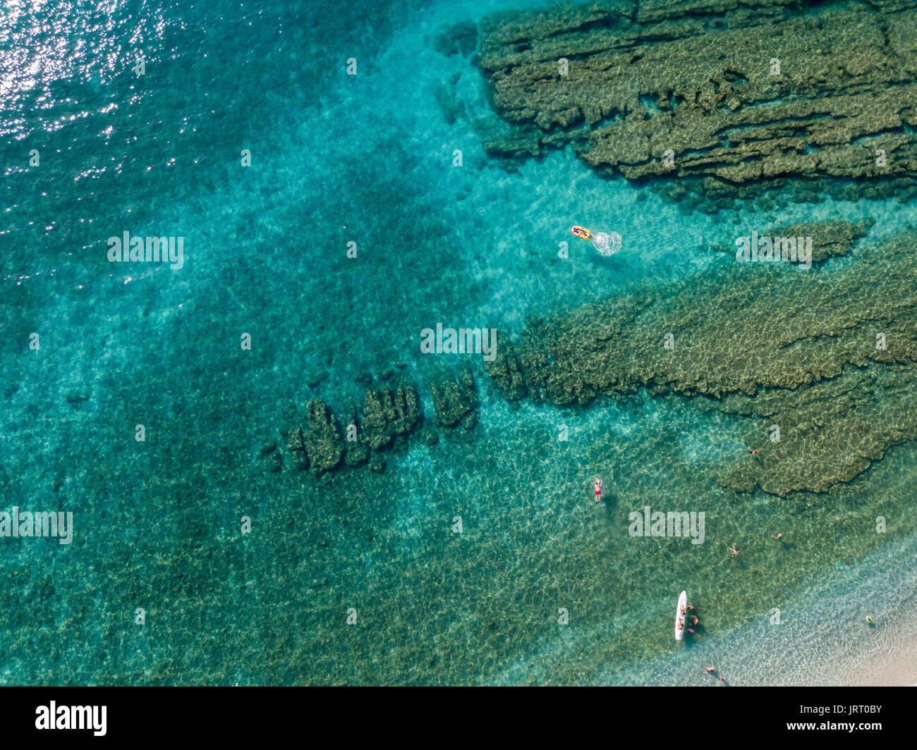 Aerial view of a canoe in the water floating on a transparent sea ...