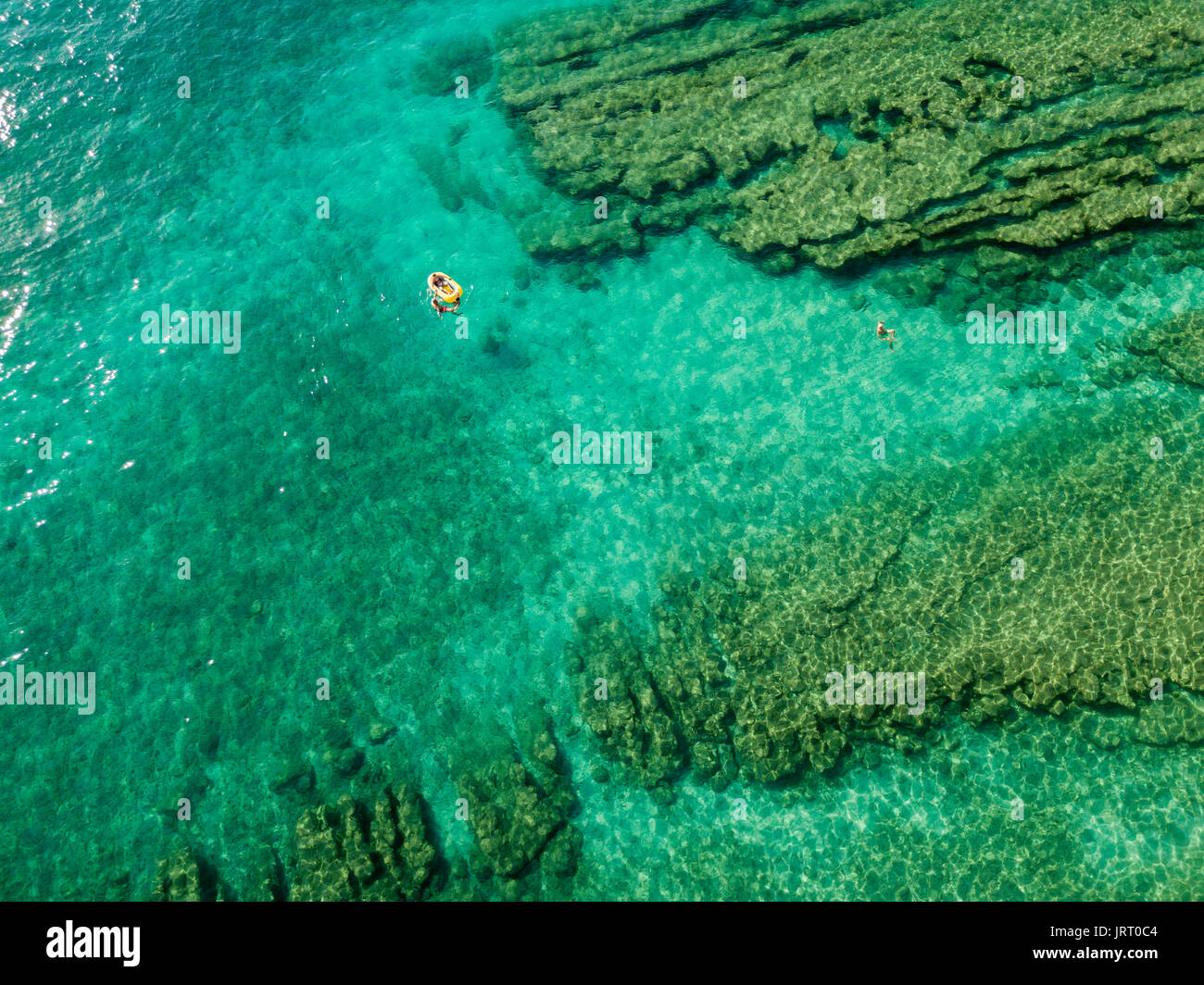 Aerial view of a canoe in the water floating on a transparent sea ...