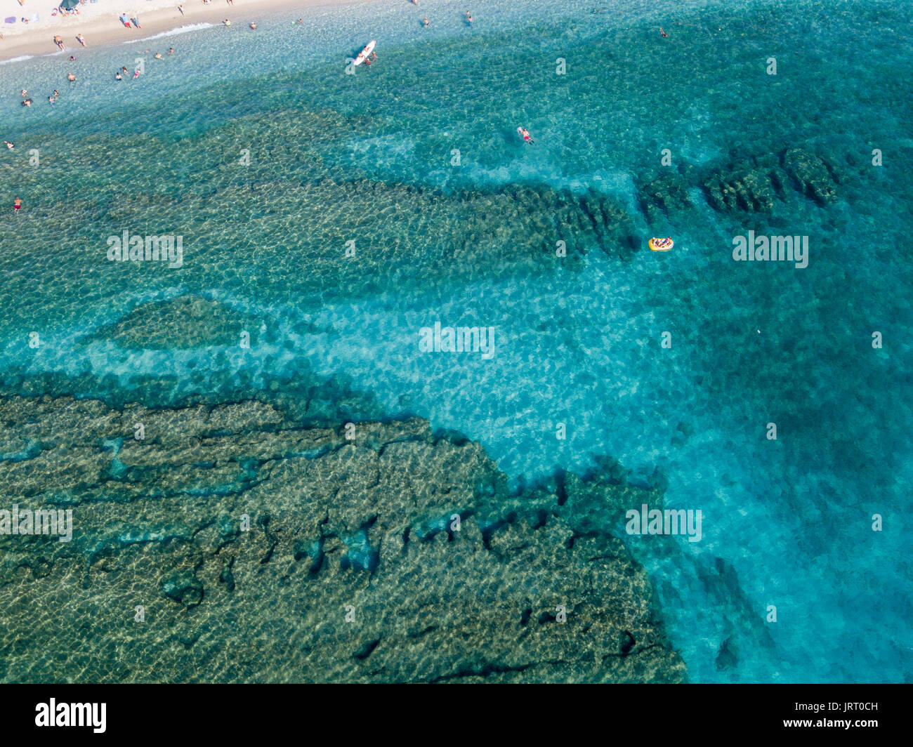 Aerial view of a canoe in the water floating on a transparent sea ...