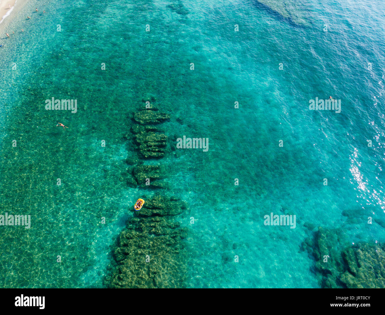 Aerial view of a canoe in the water floating on a transparent sea ...