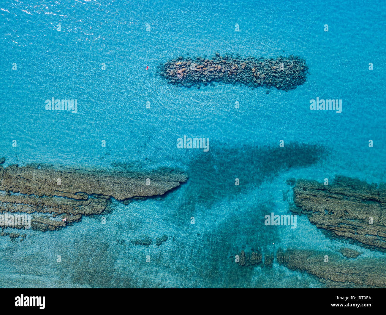 Aerial view of a canoe in the water floating on a transparent sea ...
