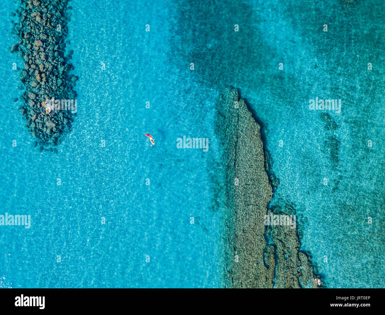 Aerial view of a canoe in the water floating on a transparent sea ...