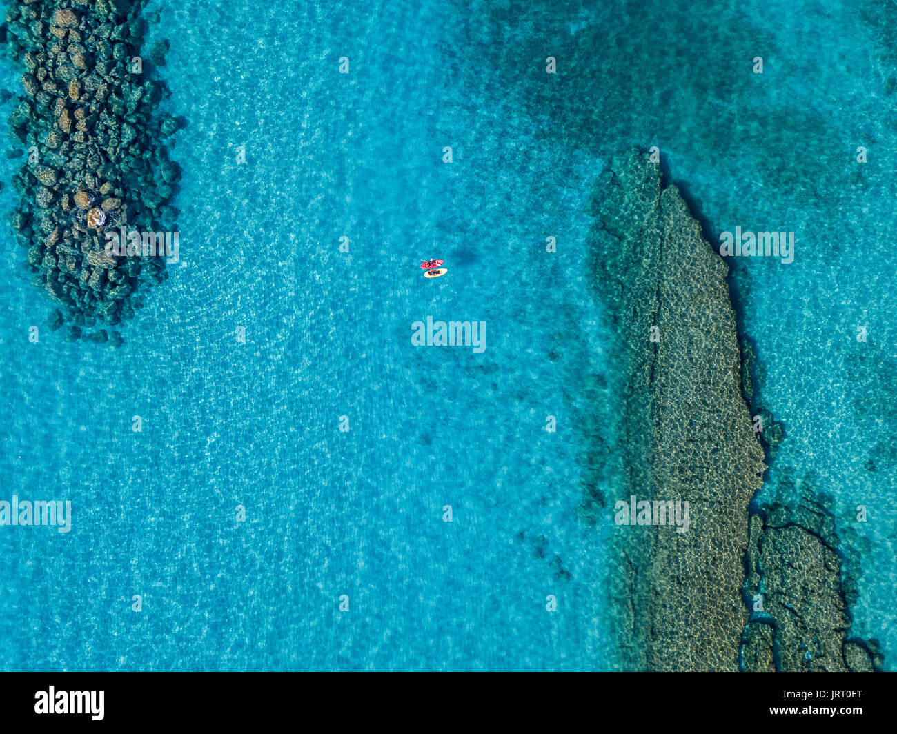 Aerial view of a canoe in the water floating on a transparent sea ...