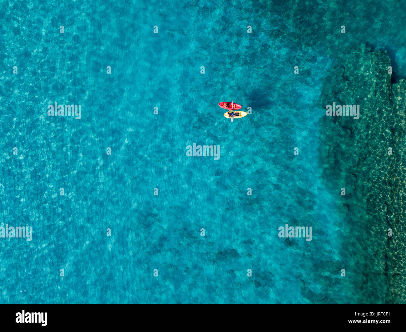 Aerial view of a canoe in the water floating on a transparent sea ...