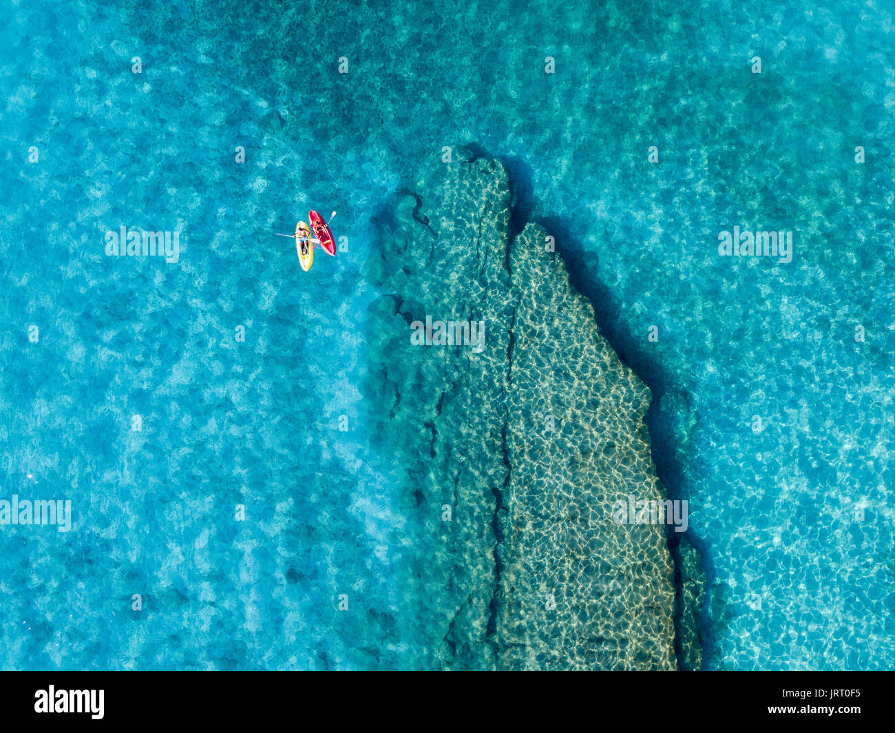 Aerial view of a canoe in the water floating on a transparent sea ...
