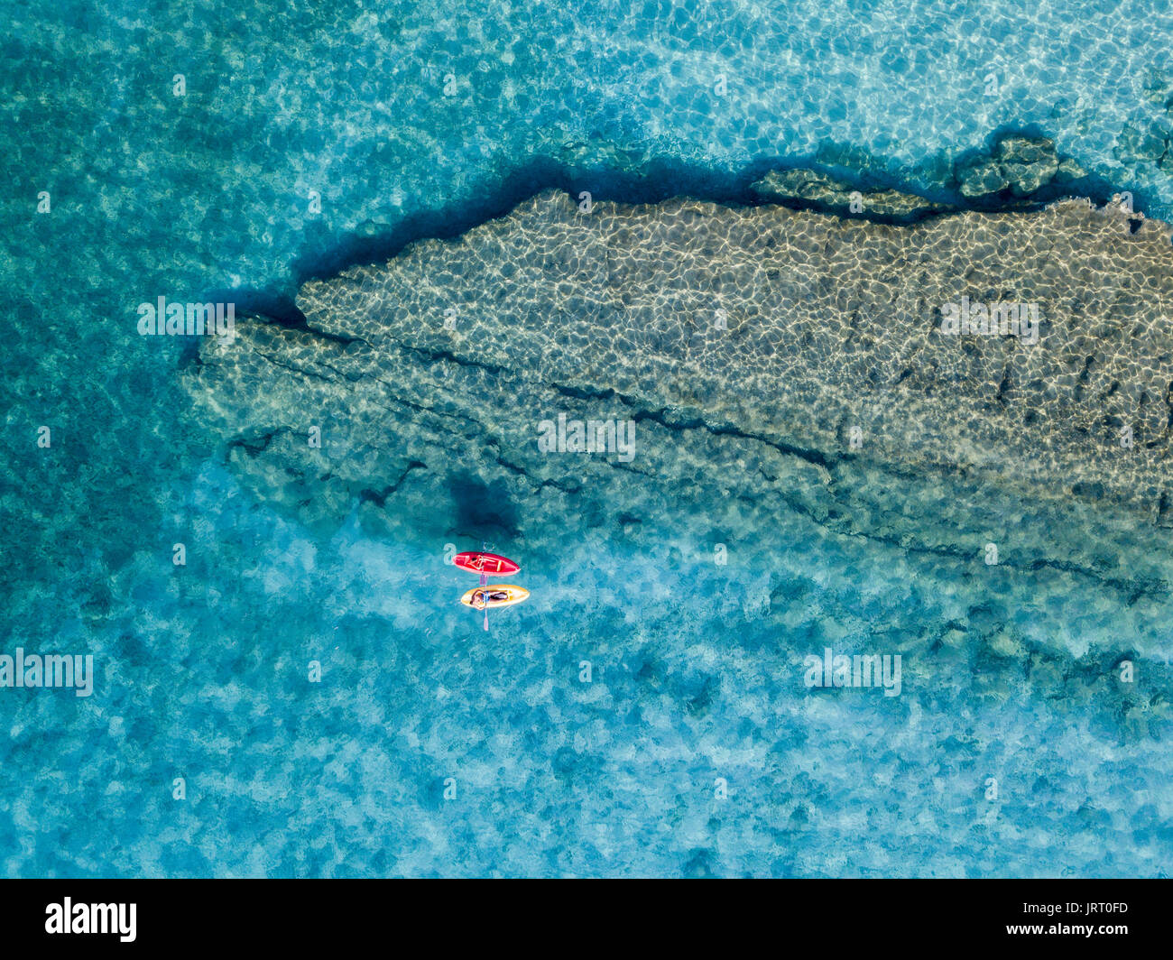 Aerial view of a canoe in the water floating on a transparent sea ...