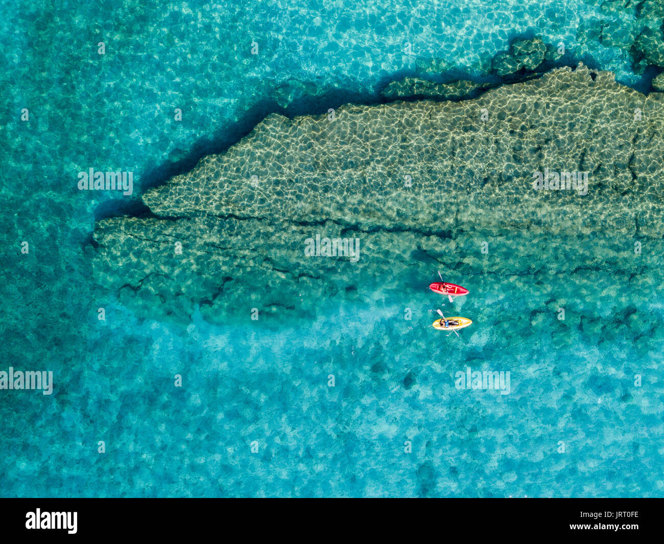 Aerial view of a canoe in the water floating on a transparent sea ...