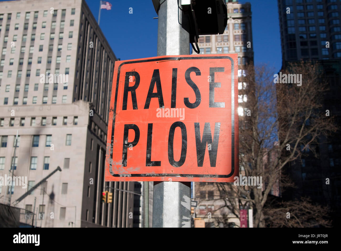 Orange 'Raise Plow' sign on display in Manhattan Stock Photo - Alamy