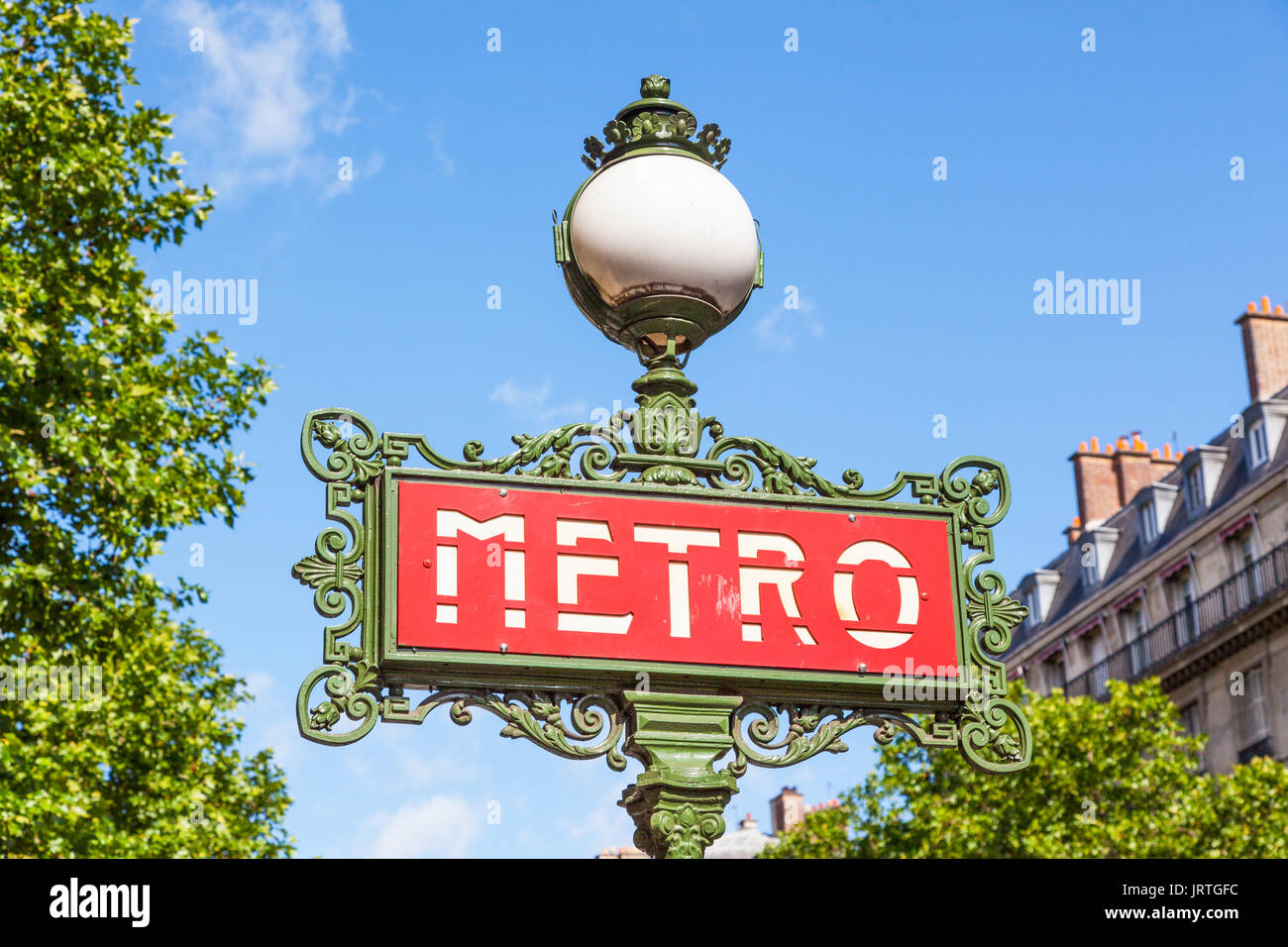 A Paris Metro sign crowned by a spherical lamp in the Art Nouveau style ...
