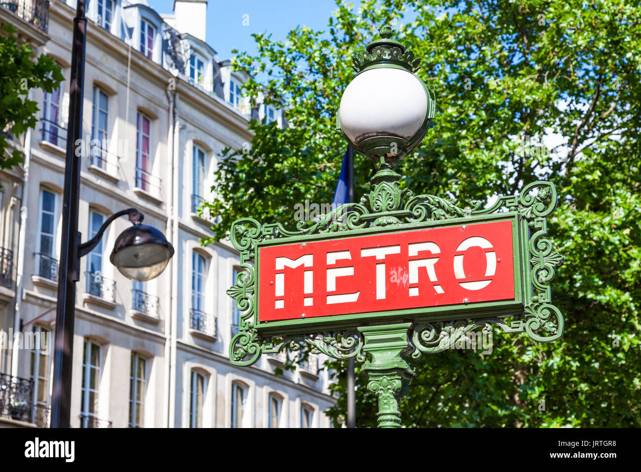 A Paris Metro sign crowned by a spherical lamp in the Art Nouveau style ...