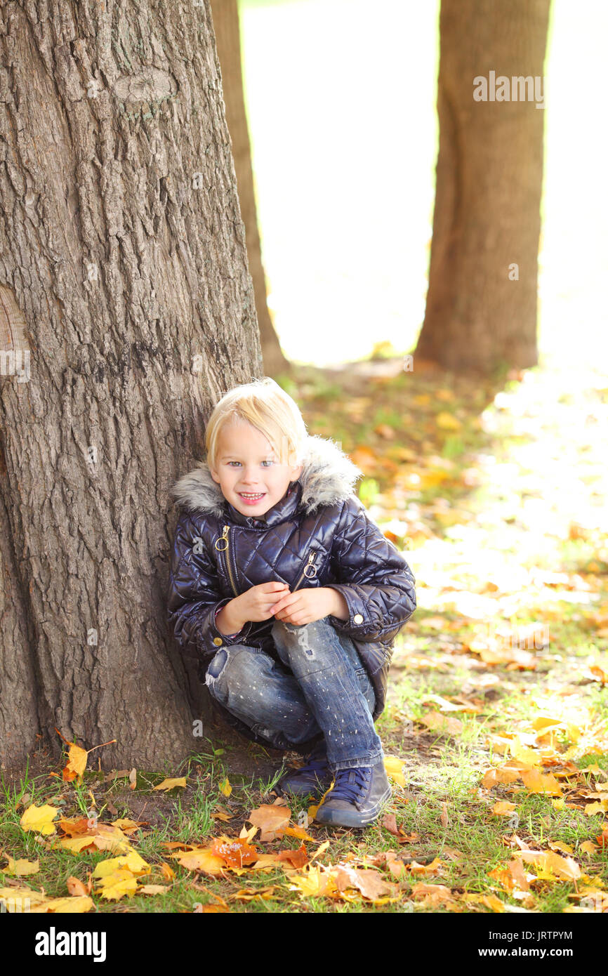 Boy sitting under tree in hi-res stock photography and images - Alamy