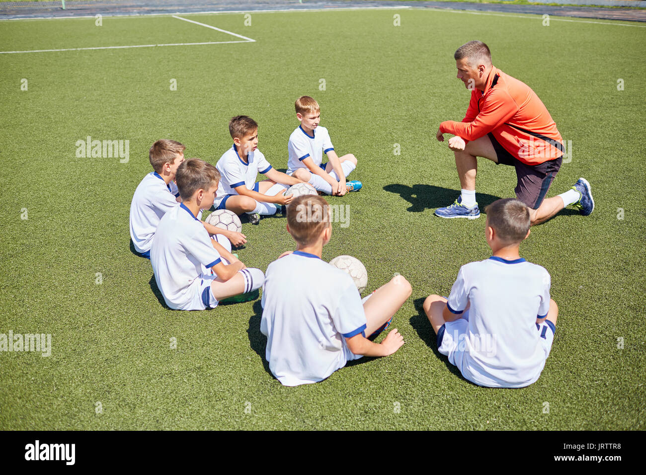 Coach Teaching Junior Football Team Stock Photo - Alamy