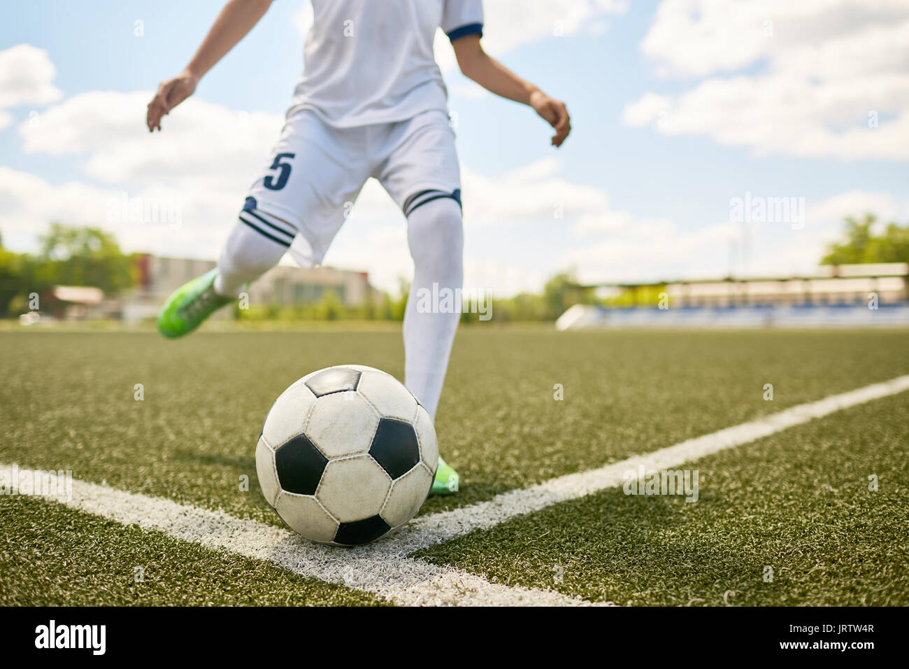 Boy Kicking Ball on Football Field Stock Photo - Alamy