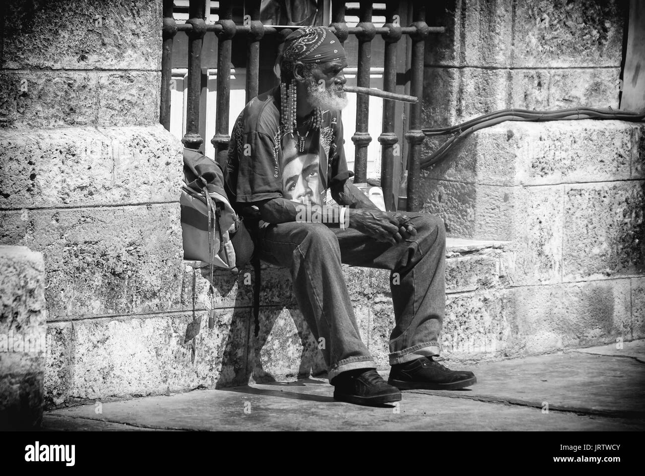 HAVANA, CUBA - FEBRUARY 23, 2010: Old man smoking a big cigar while ...