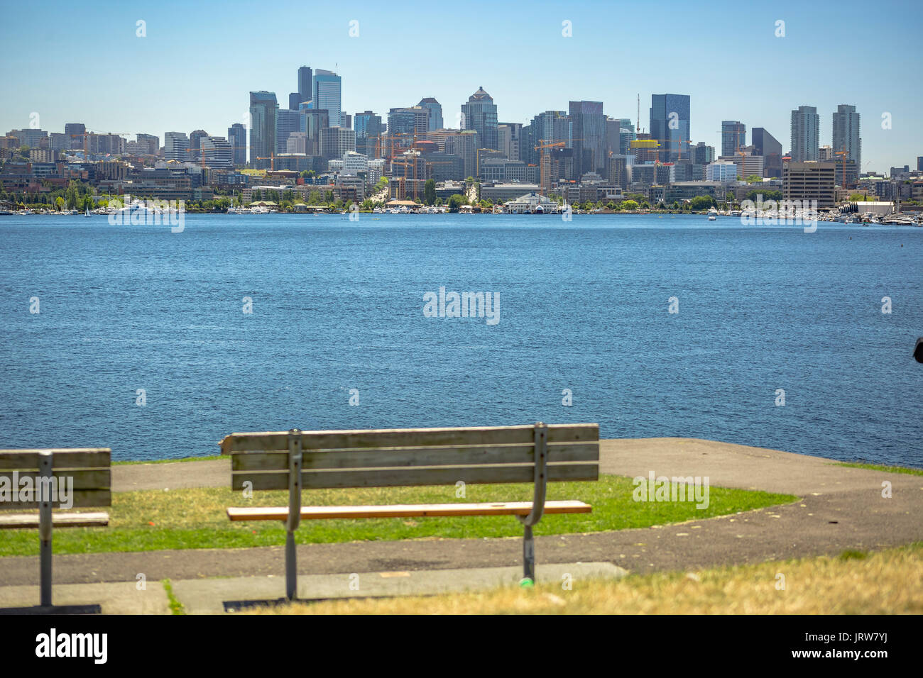 Sun over Seattle, park bench in the foreground. Park bench water and ...