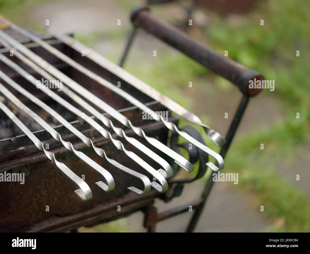 Bunch of metal barbecue skewers laid in the bbq trolley, shallow depth ...