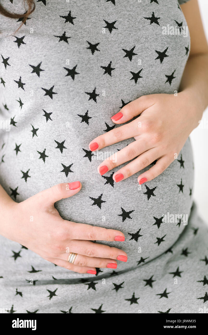 pregnancy, femininity, birth of children concept - closeup on round ...