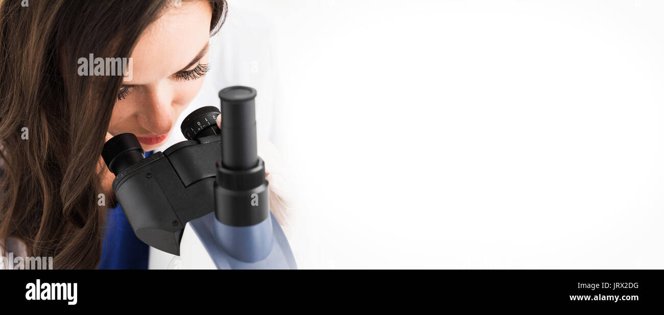 Female doctor looking through a microscope, studio shot isolated on ...