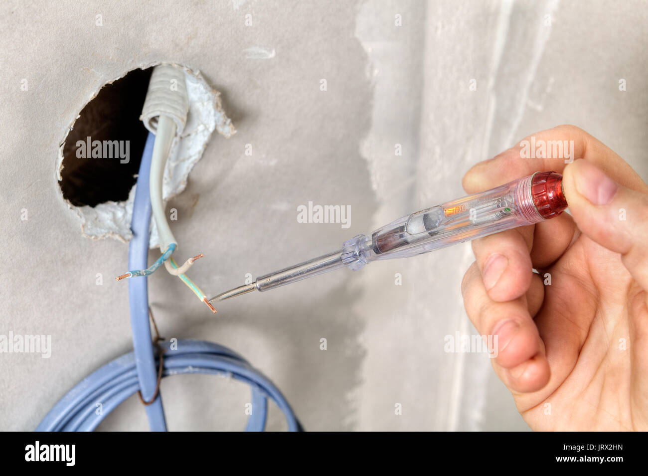 Close-up of a hand electrician check the phase of the electric wire ...