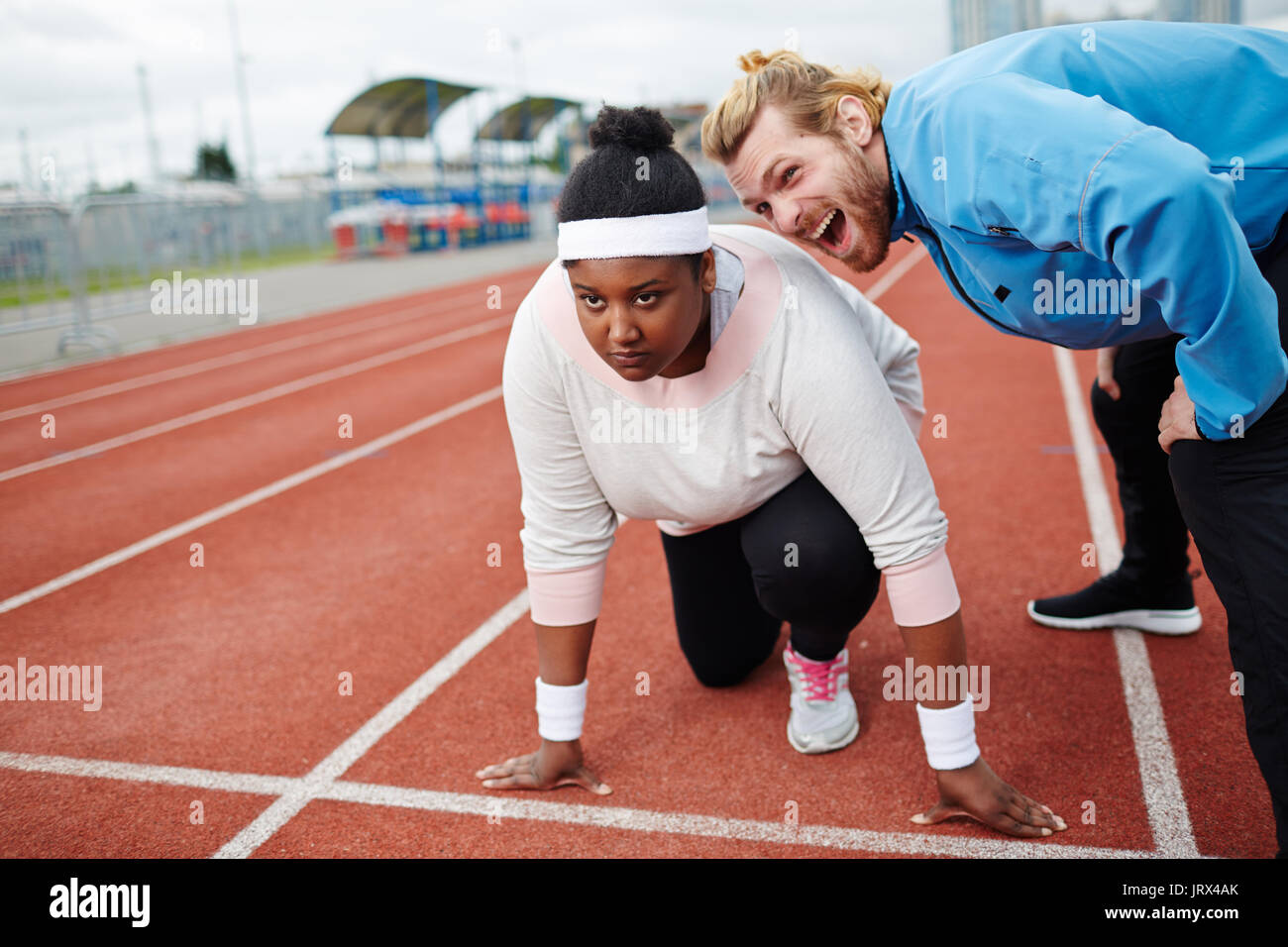 Personal trainer motivating overweight woman preparing for run ...