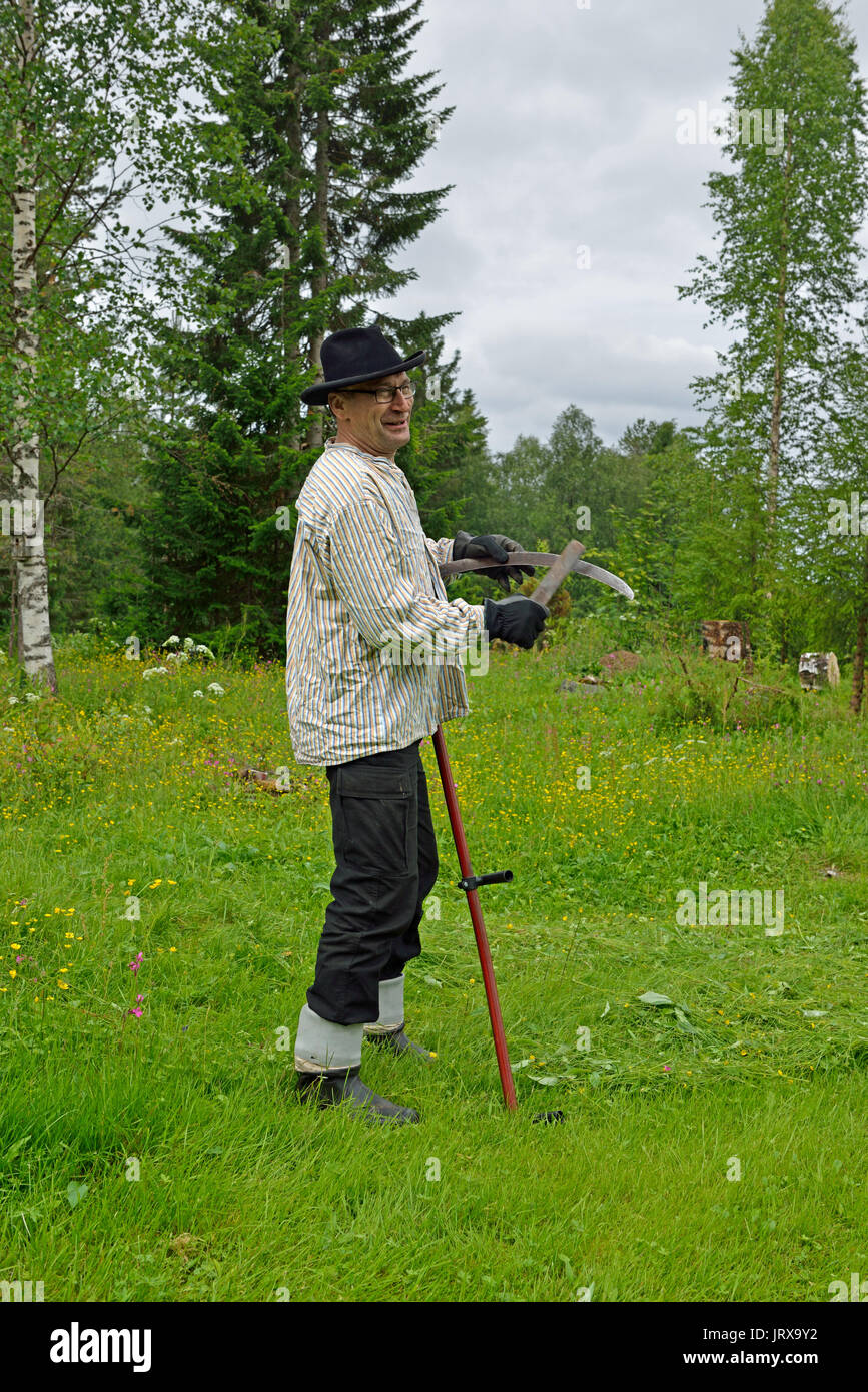 Middle-aged farmer honed traditional wooden scythe Stock Photo - Alamy