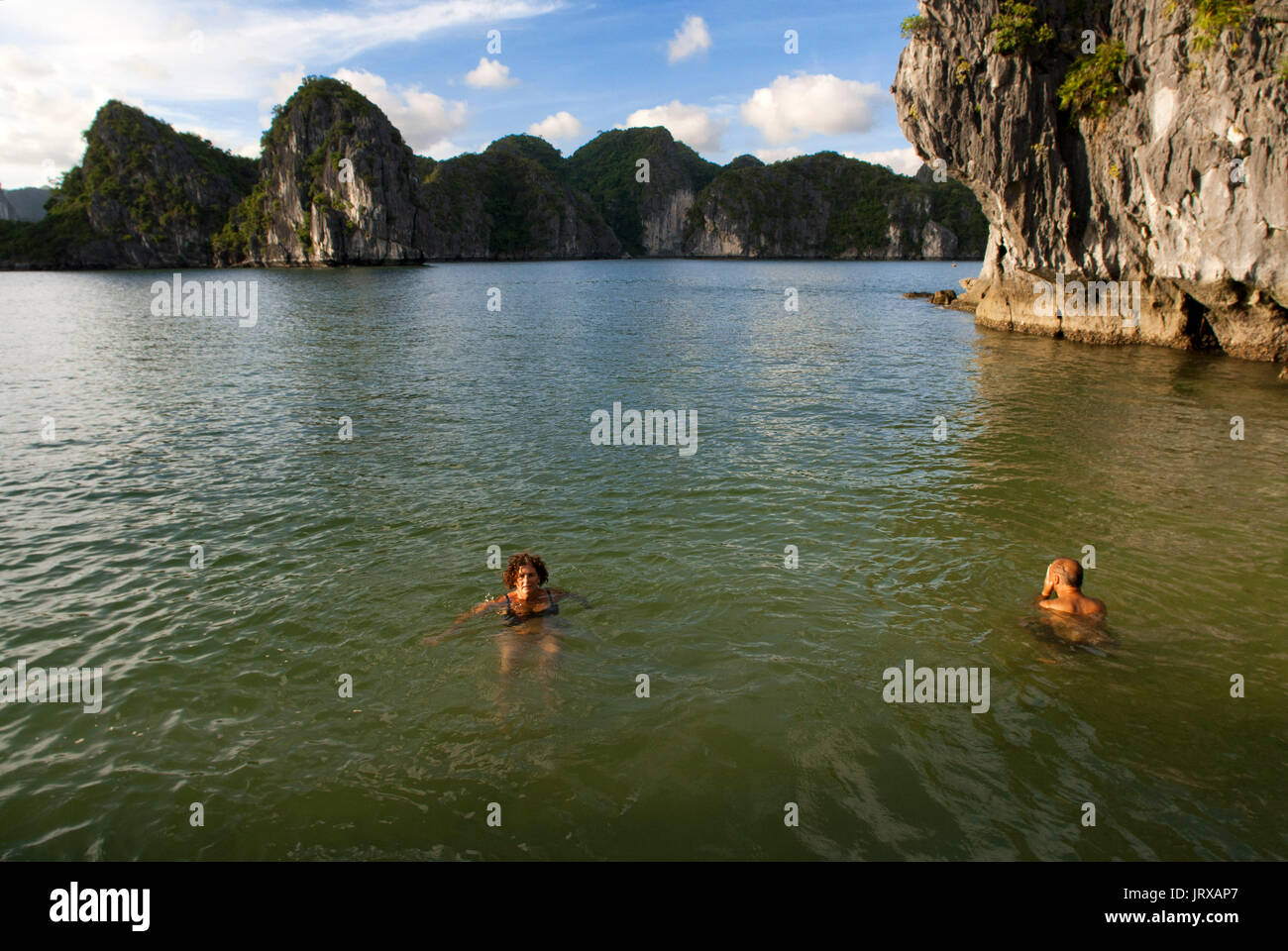 People swmming in secluded beach in isolated island in Ha Long Bay ...