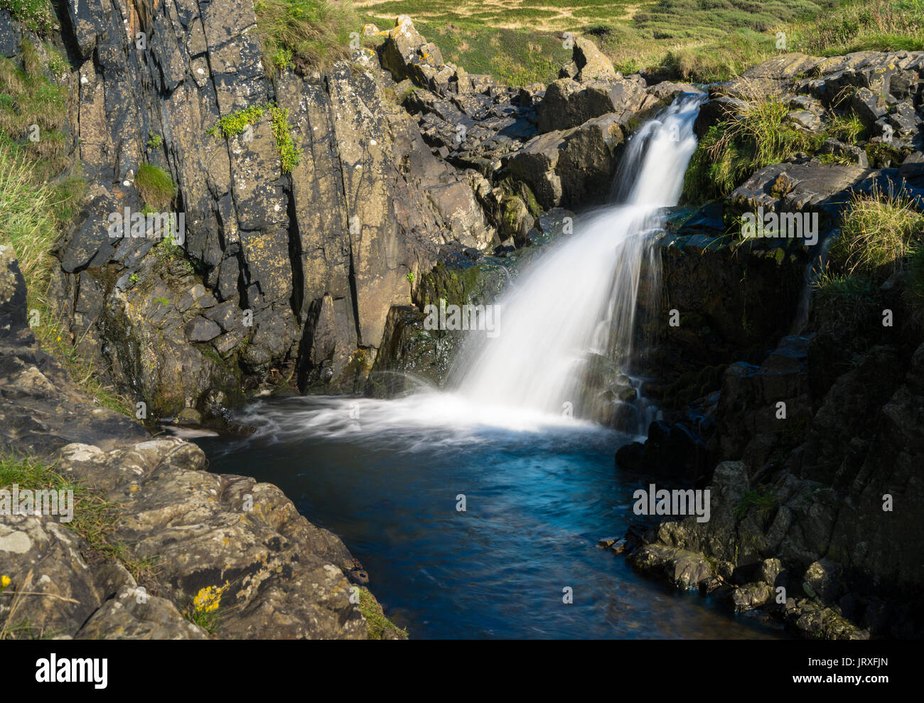 Waterfall into ocean at Welcome Mouth in Devon Stock Photo - Alamy