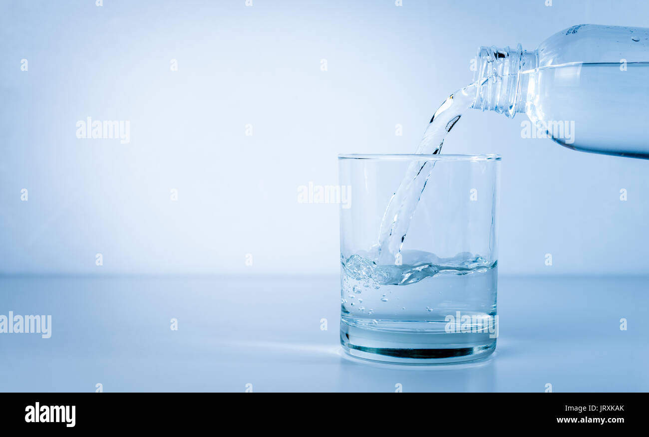 pouring water from bottle into glass Stock Photo - Alamy