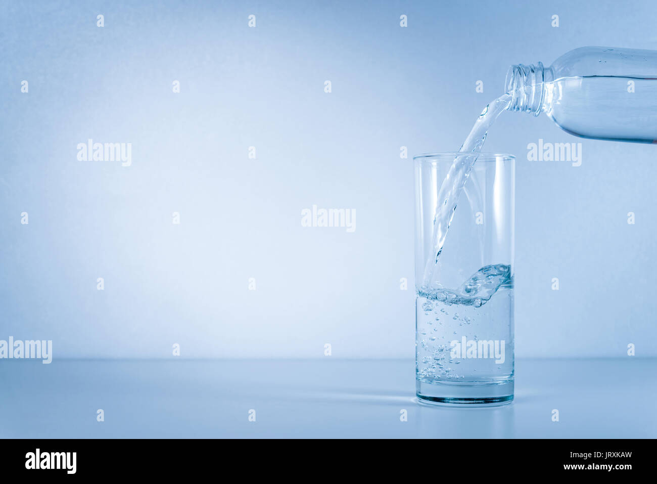 pouring water from bottle into glass Stock Photo - Alamy