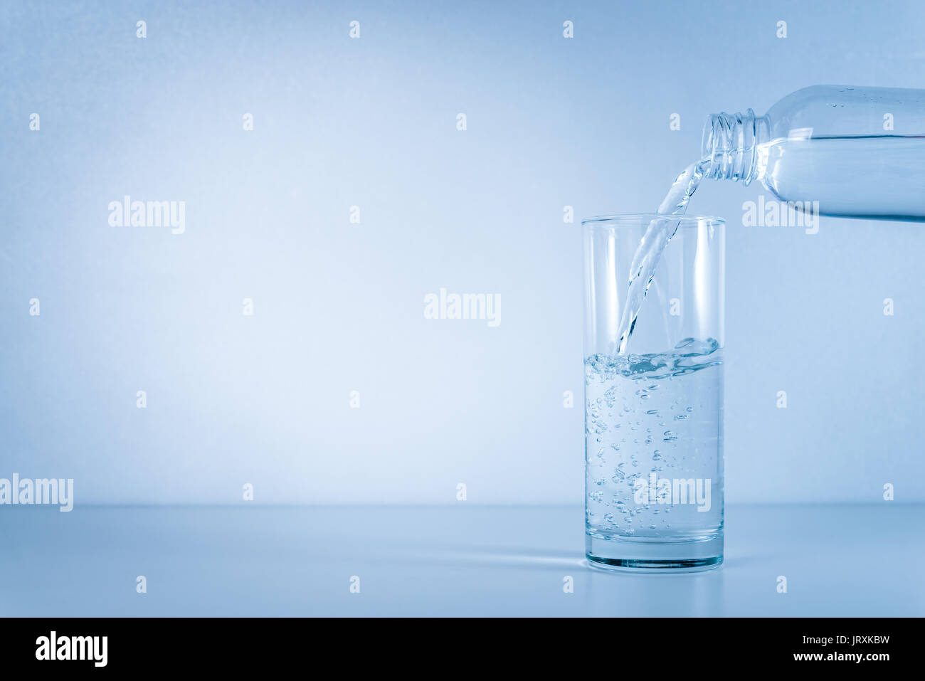 pouring water from bottle into glass Stock Photo - Alamy