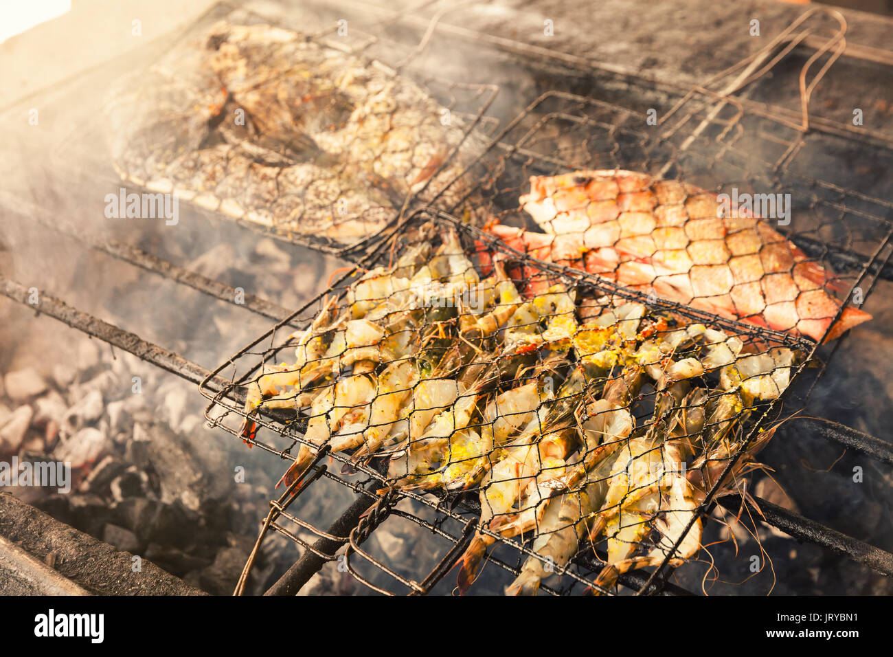 Grilled fresh seafood: parrot fish, octopus, shrimp food background ...