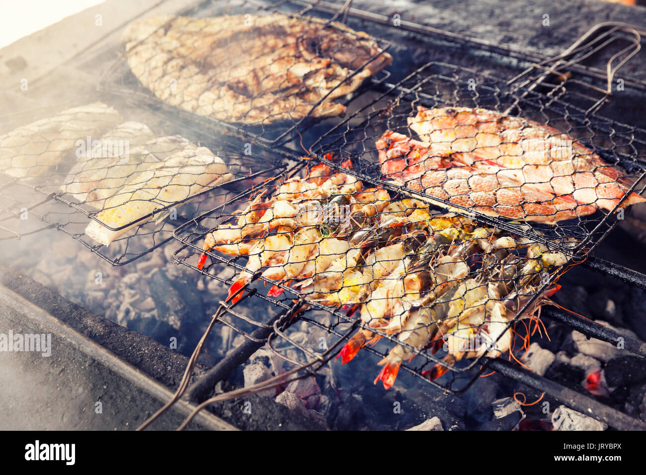 Grilled fresh seafood: parrot fish, octopus, shrimp food background ...