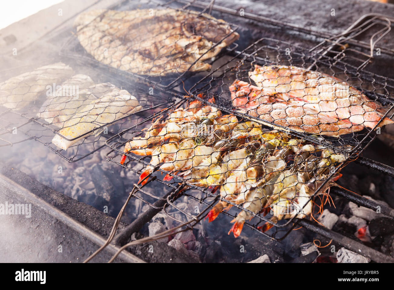 Grilled fresh seafood: parrot fish, octopus, shrimp food background ...