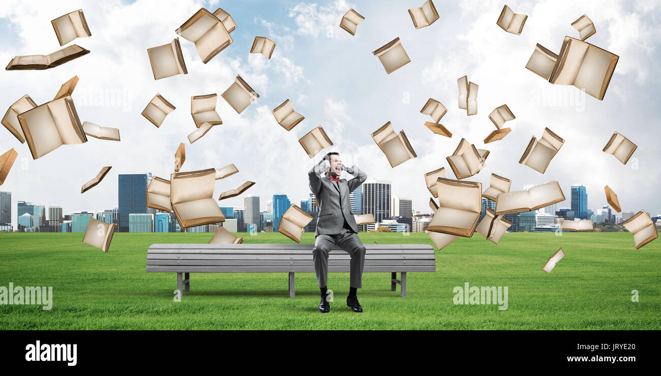 Many old books falling from above and student guy sitting on bench ...