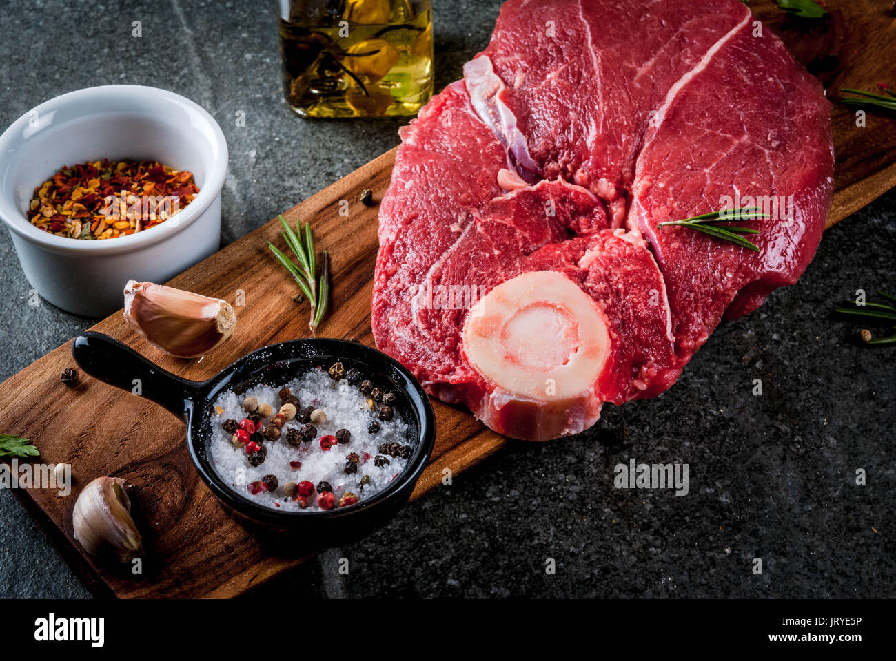 Raw meat with ingredients for cooking. Beef fillet, tenderloin on bone ...