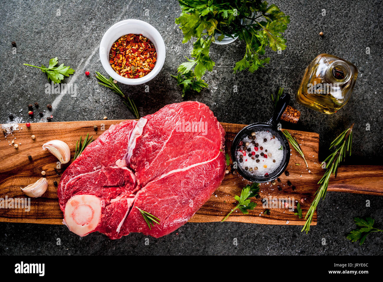 Raw meat with ingredients for cooking. Beef fillet, tenderloin on bone ...