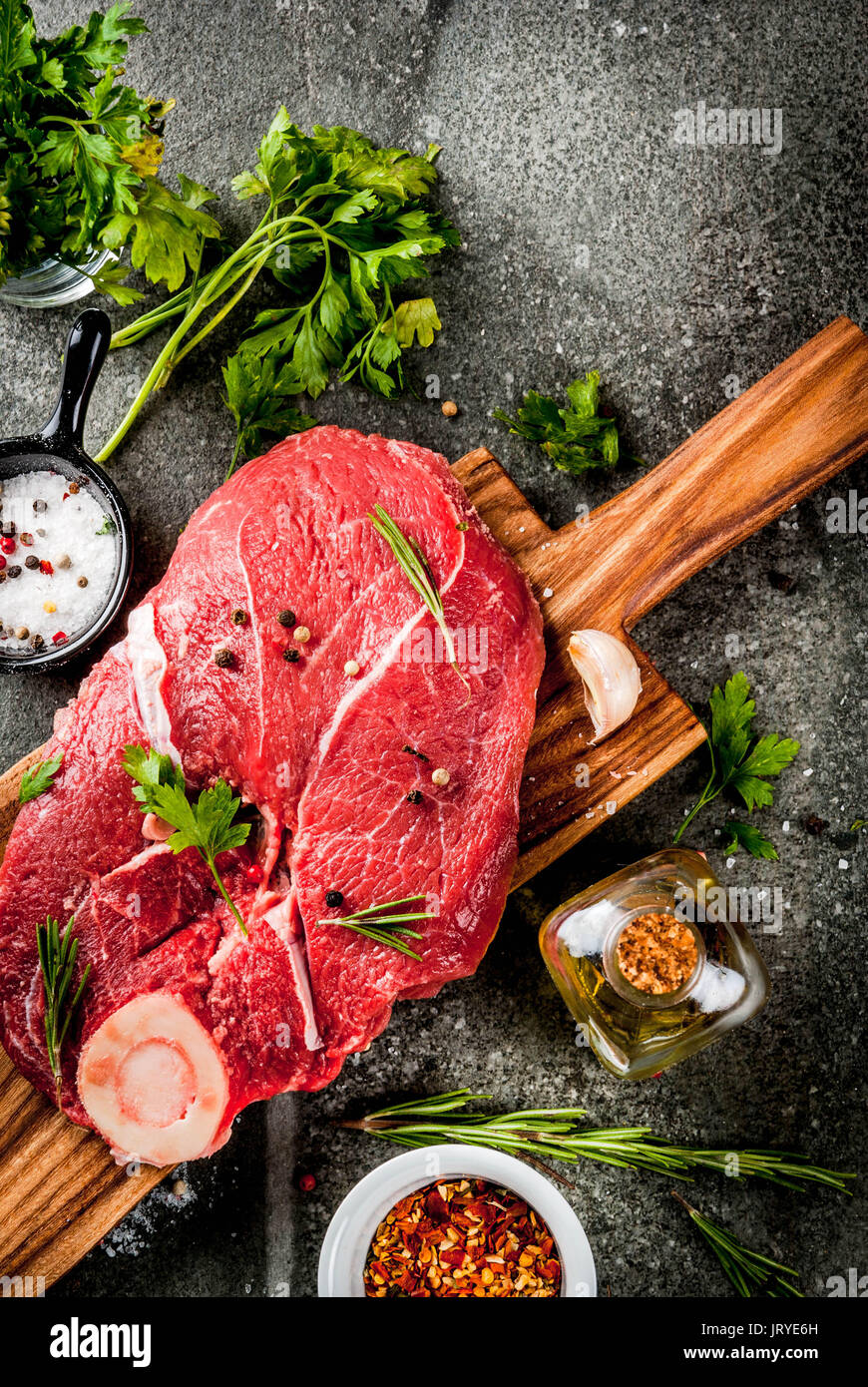 Raw meat with ingredients for cooking. Beef fillet, tenderloin on bone ...