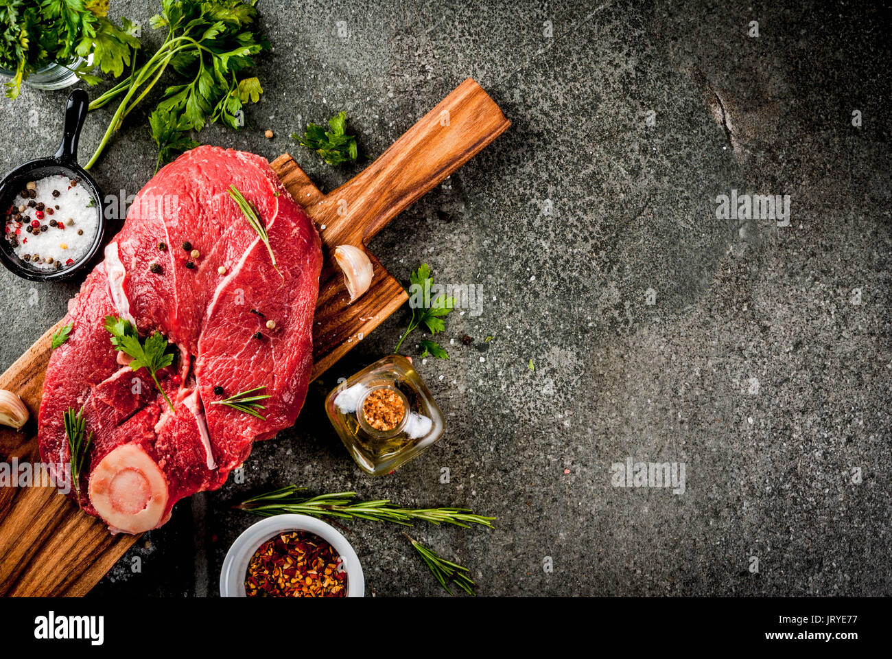 Raw meat with ingredients for cooking. Beef fillet, tenderloin on bone ...