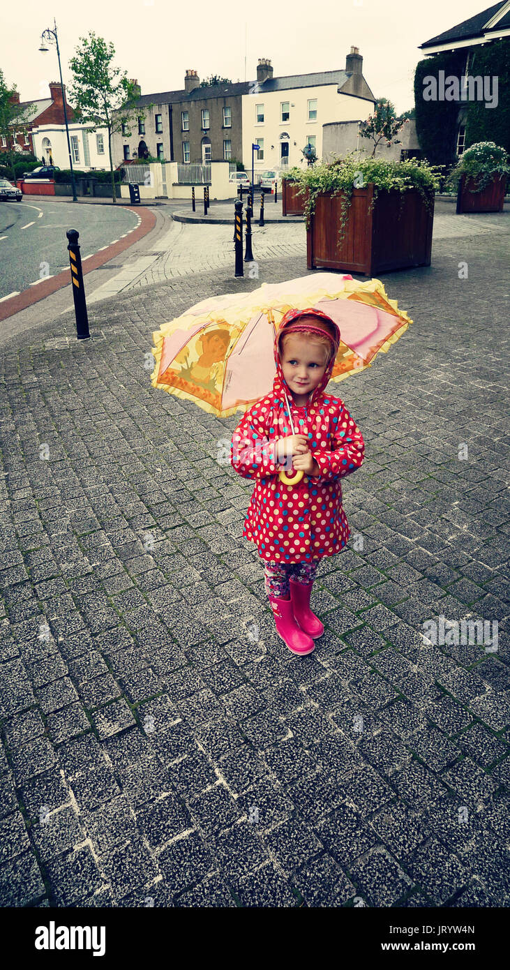 Three year old little girl, child, kid wearing a spotty raincoat and ...