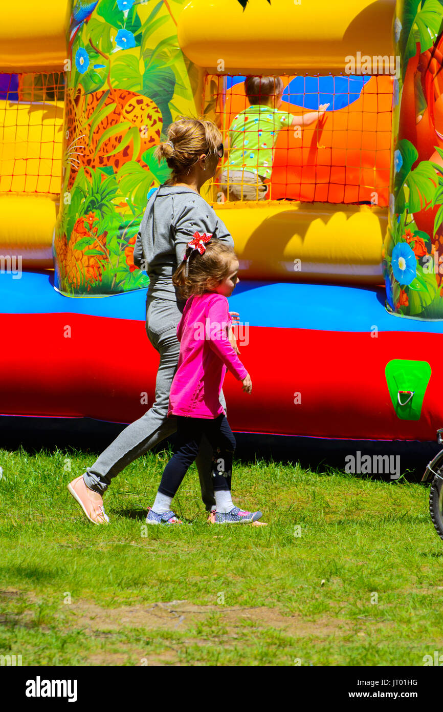 Children play on the inflatable children's playground in the city park ...