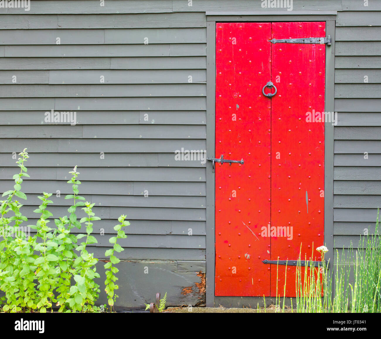 bright red door in brown wall of colonial building Stock Photo - Alamy