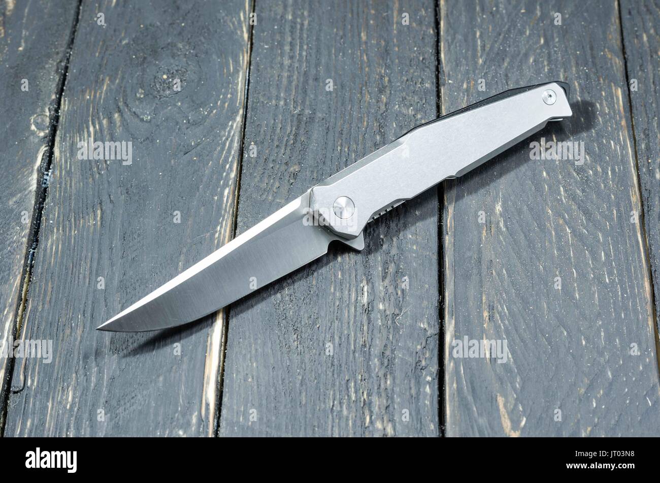 Knife with an iron grip and shiny blade. Black wood background Stock ...