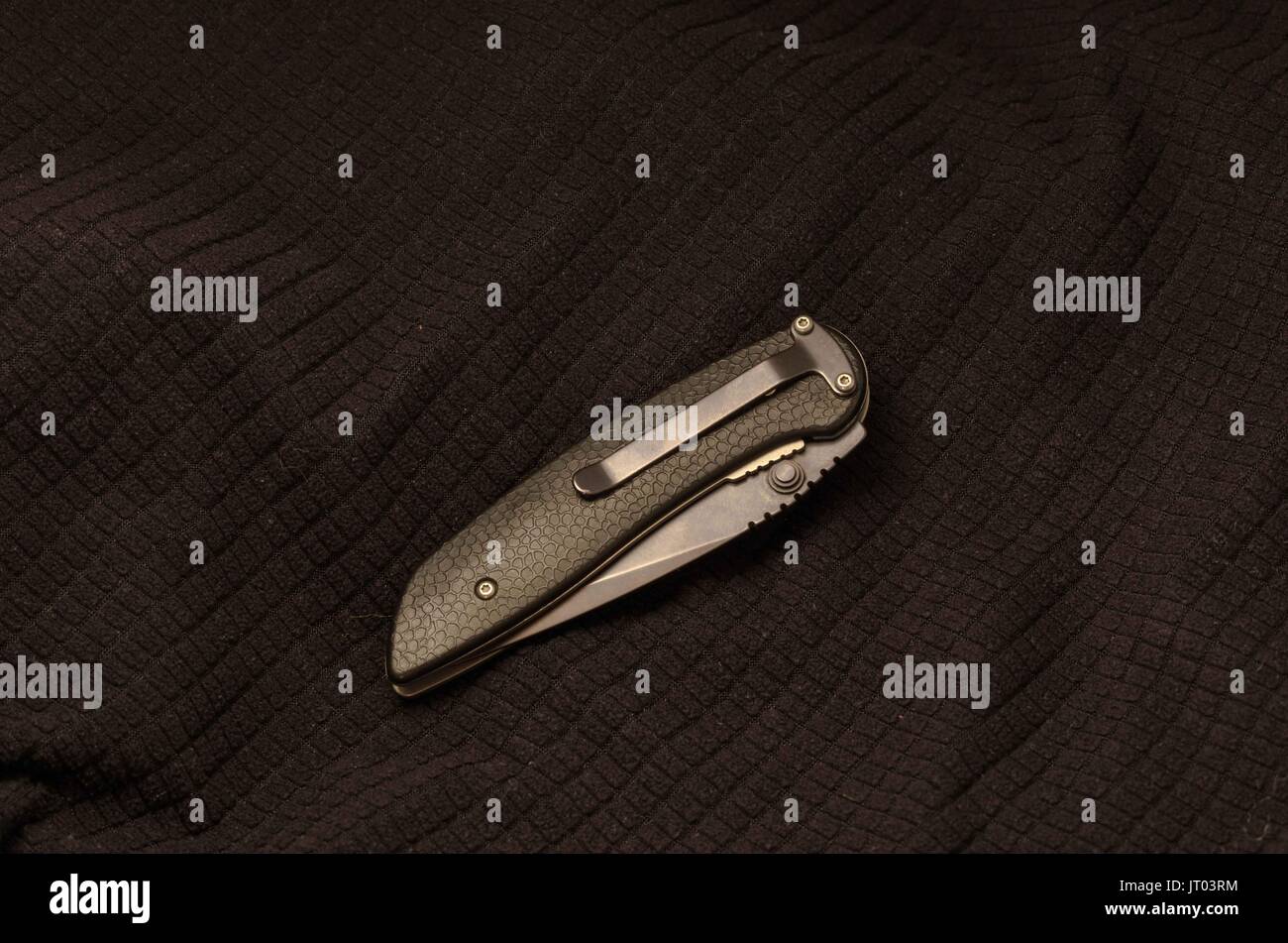 Black knife folded on a black background. Back side Stock Photo - Alamy