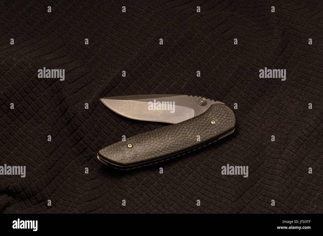 Black knife in a curved shape on a black background Stock Photo - Alamy