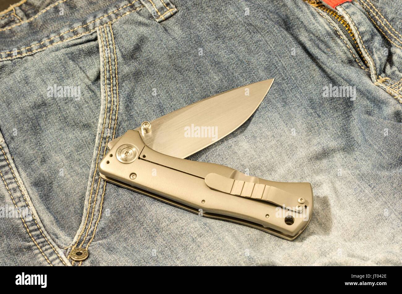 Folding knife with aluminum handle. The knife is in a curved position ...