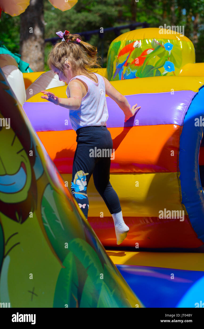 Children play on the inflatable children's playground in the city park ...