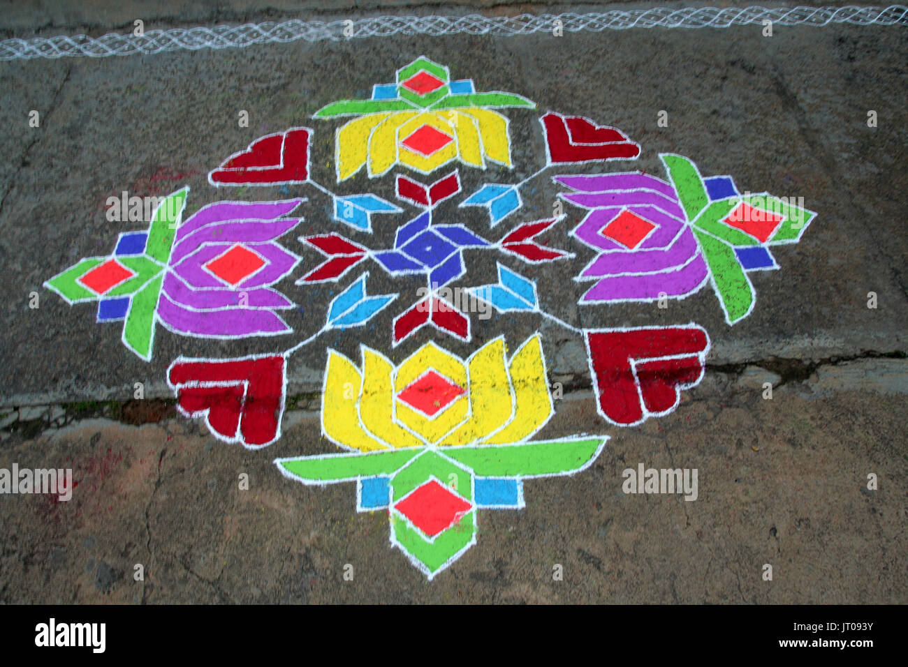 Creation of geometrical design in Rangoli art using stone powder mixed ...