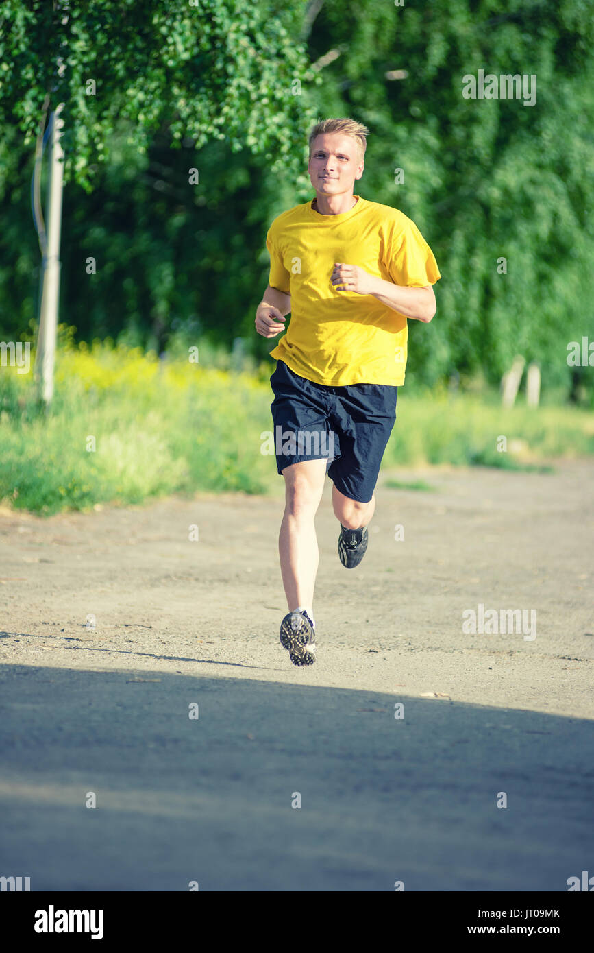Running man jogging in city street park at beautiful summer day. Sport ...