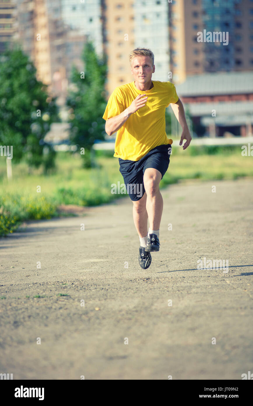 Running man jogging in city street park at beautiful summer day. Sport ...